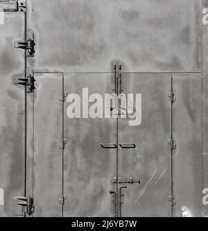 Portes de garage peintes en noir avec porte sous la lumière du soleil ...