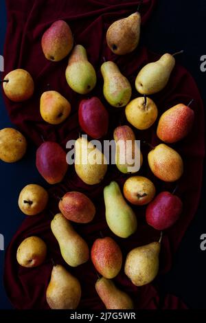 Les poires juteuses jaunes et rouges se trouvent sur une assiette de ...