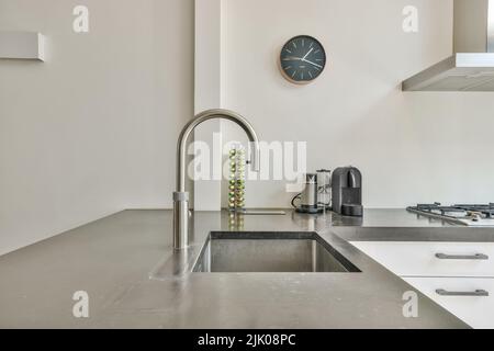 Évier avec robinet brillant installé sous le comptoir moderne près du ...