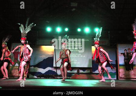 Les hommes portant une tenue traditionnelle Dayak exécutent une danse ...