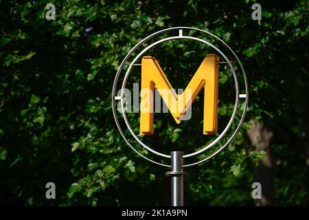 L'illustration montre un panneau avec le logo du métro (symbole jaune ...