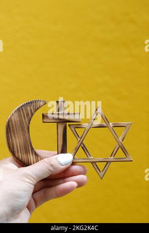 Symboles religieux en main. Étoile juive de David, étoile musulmane et ...