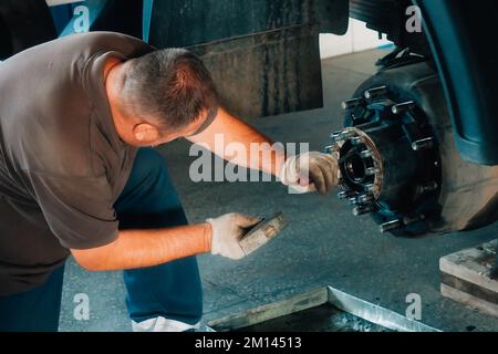 Le mécanicien d'automobiles répare le chariot. Réparation et diagnostic ...