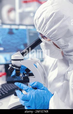 Medic ou scientifique regardant à travers un microscope dans un ...
