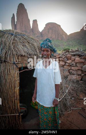 Peul femme devant la cabane de paille avec vue sur le fond de la vallée ...