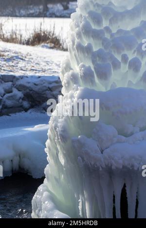 Fontaine glacée dans le parc par une journée ensoleillée en hiver ...