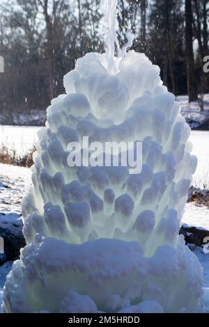Fontaine glacée dans le parc par une journée ensoleillée en hiver ...