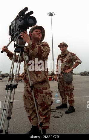 Le photographe Mate 2nd Class Keith Tayman, au centre, filme un membre ...