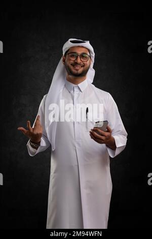 Arabe Qatari homme utilisant le tablate et posant sur un fond isolé ...