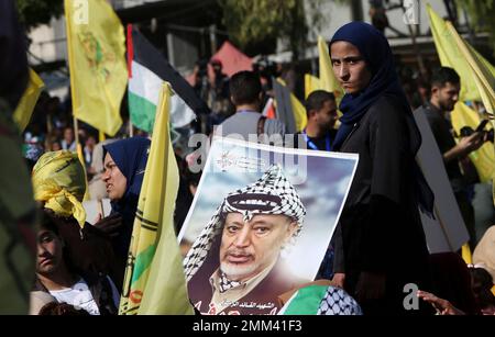 Palestinians celebrate while waving yellow Fatah flags and a picture of ...