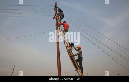 Indian linemen fix new high tension electric power line on the banks of ...