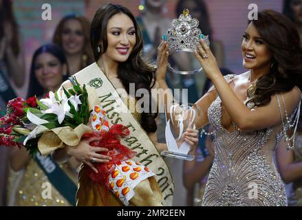 Karen Ibasco, left, of the Philippines receives the crown from last ...
