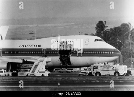 Two inspectors look at the severely damaged United Airlines Flight 811 ...