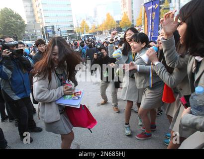 South Korean students and their senior, left, bow each other to pray ...