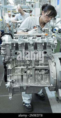 A worker completes the new four-cylinder diesel engine OM 654 during ...