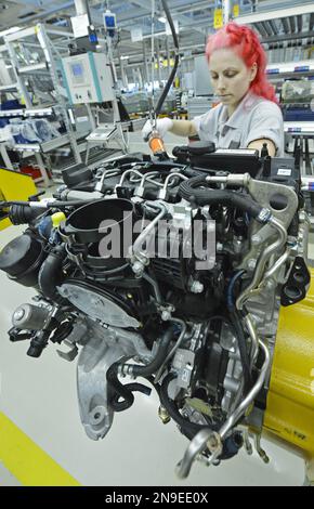 A worker completes the new four-cylinder diesel engine OM 654 during ...