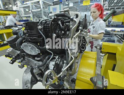 A worker completes the new four-cylinder diesel engine OM 654 during ...