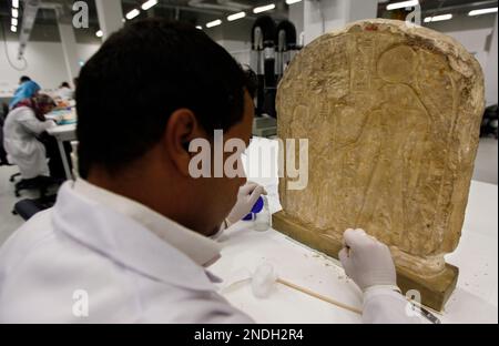 An Egyptian archeological technician works at a pharonic falcon mummy ...