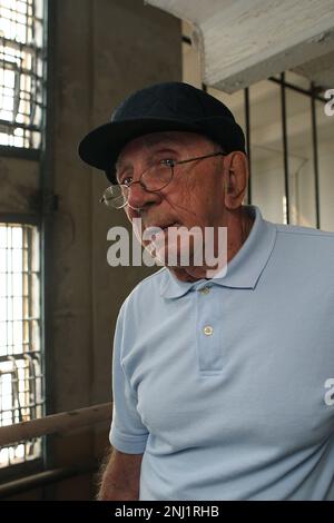 Former prisoner Bill Baker, 80 years old, looks up at the empty cell ...