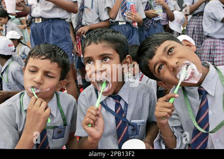 Indian school children brush their teeth together in an attempt to ...