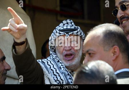Palestinian leader Yasser Arafat salutes as he stands in front of a ...