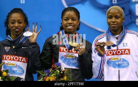 Canada's Perdita Felicien, 2nd left, looks up after crossing the line ...