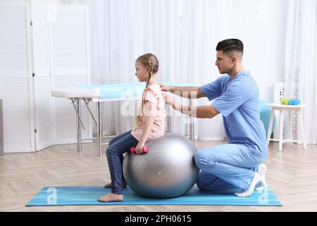 Orthopédiste aidant le patient à faire de l'exercice avec haltères en ...