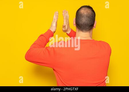 Un demi-bald qui claque énergiquement son dos, il est excité par le ...