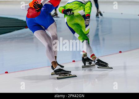 les patineurs masculins de jambes font une compétition de patinage de ...