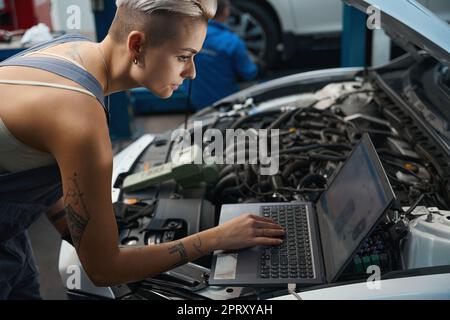 Le mécanicien de l'atelier de réparation automobile effectue une ...