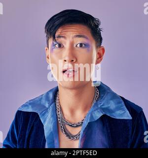 Homme de choc, surprise et gay avec maquillage en studio isolé sur fond ...
