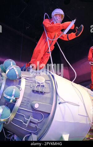 Un cosmonaute russe dans un costume d'espace orange flotte au-dessus d ...