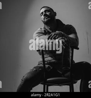 Homme alcoolique avec bouteilles de vin cri.Pleurer l'homme enfoncé ...