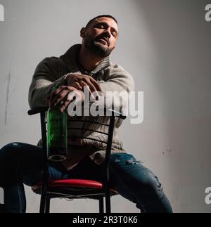 Homme alcoolique avec bouteilles de vin cri.Pleurer l'homme enfoncé ...
