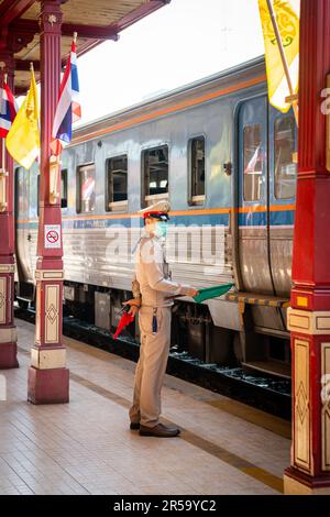 Un garde-train thaïlandais se tient sur le quai de la gare de Hua Hin ...
