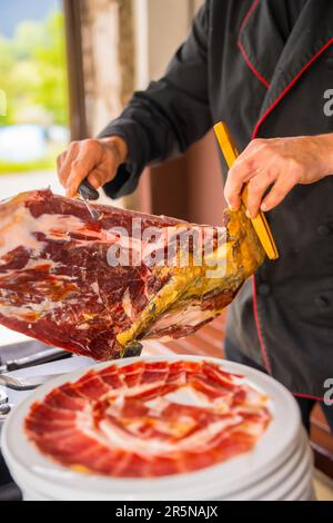 Détail d'un homme qui coupe du jambon ibérique lors d'un mariage ou d ...