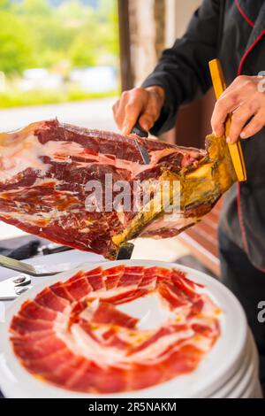 Détail d'un homme qui coupe du jambon ibérique lors d'un mariage ou d ...