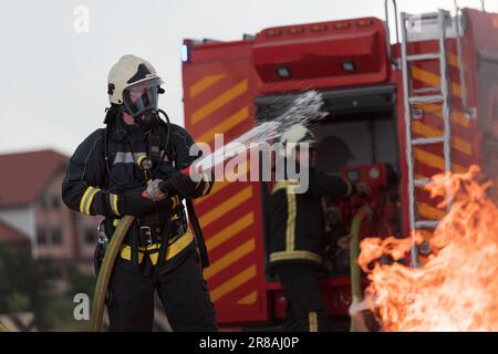Les pompiers utilisant un extincteur de type brouillard d'eau pour ...
