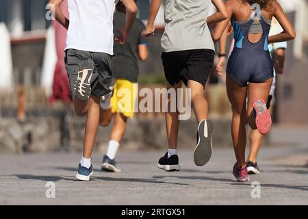 Courir les enfants, les jeunes athlètes courent dans une course d ...