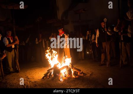On voit des villageois allumer une torche sur un feu de joie à l ...