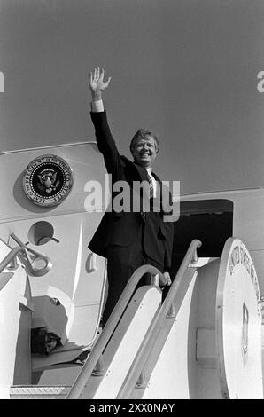President Jimmy Carter waves to the crowd while walking with his wife ...