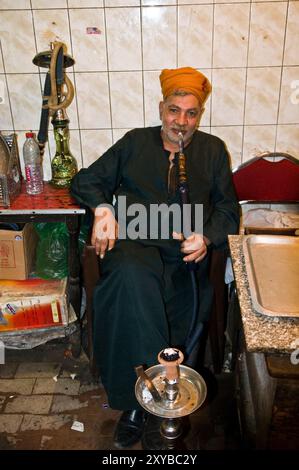 Egyptien fumant de la chicha ou du nargua dans une salle de fruits ...