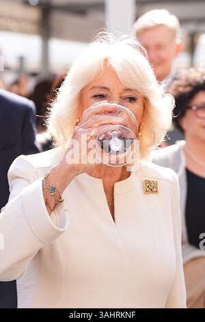 La reine Camilla boit un verre de vin rouge lors d'une visite à un ...