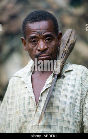 L'homme pygmée avec outil agricole sur le point de visiter son jardin ...