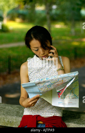 Femme de demander des directions sur le téléphone avec une carte Photo ...