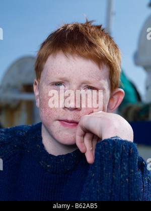 Jeune garçon aux cheveux roux et les taches de rousseur de 7 ans fixant ...