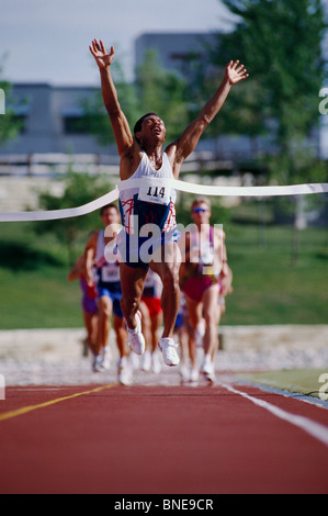 Coureur mâle victorieux à la ligne d'arrivée dans une course sur piste ...