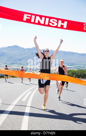 Coureur de triathlon de franchir la ligne d'arrivée au Saint Anthony's ...