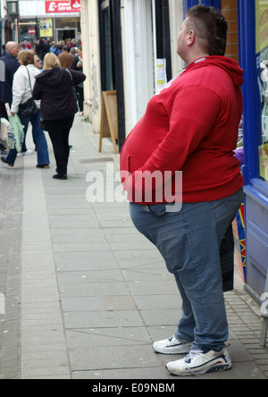 Gros Homme debout de profil et tenant son ventre, sur fond blanc Banque ...