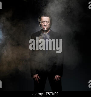 Robert Crampton qui est un fumeur studio shot porter un costume noir ...